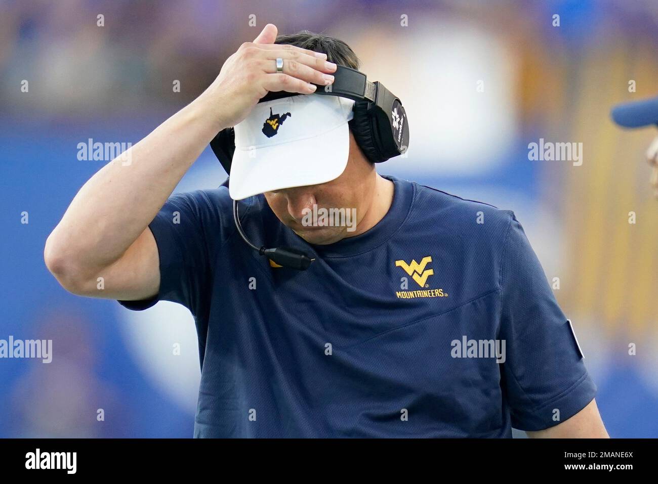 West Virginia head coach Neal Brown, in white visor, works the sideline ...
