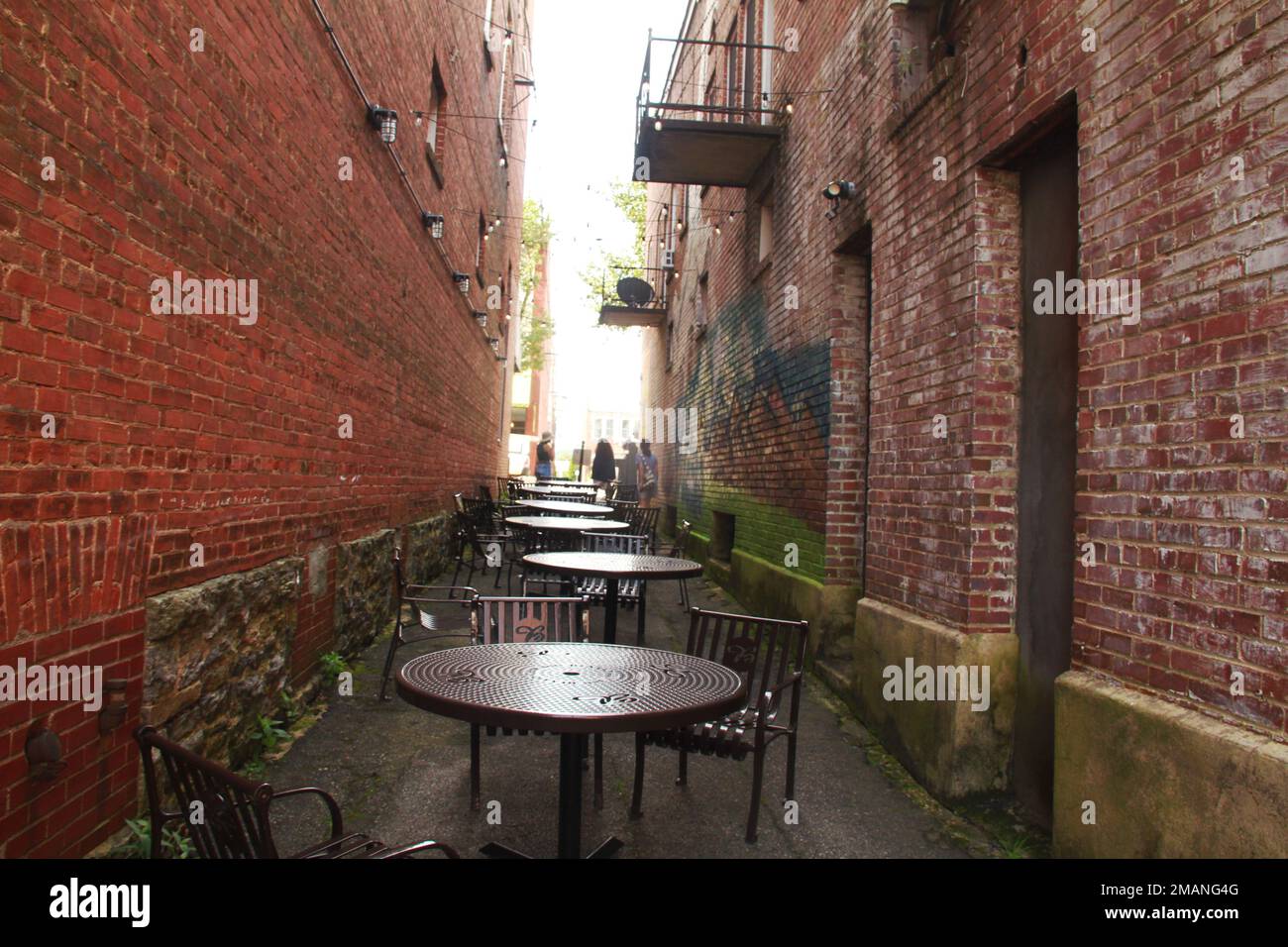 The seating area of a cafe/ restaurant on a narrow alleyway in downtown ...