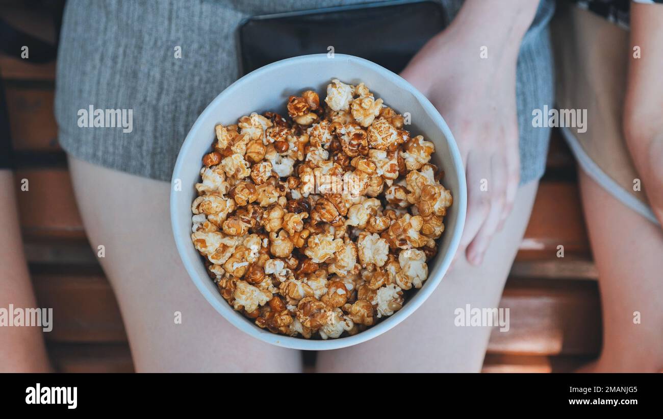 Friends eating popcorn on the street. Close-up of hands Stock Photo - Alamy