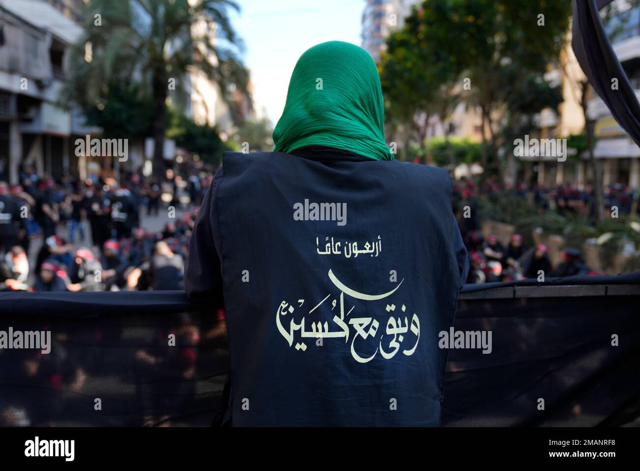 A Hezbollah member wears a vest with Arabic that reads: "40 years and ...