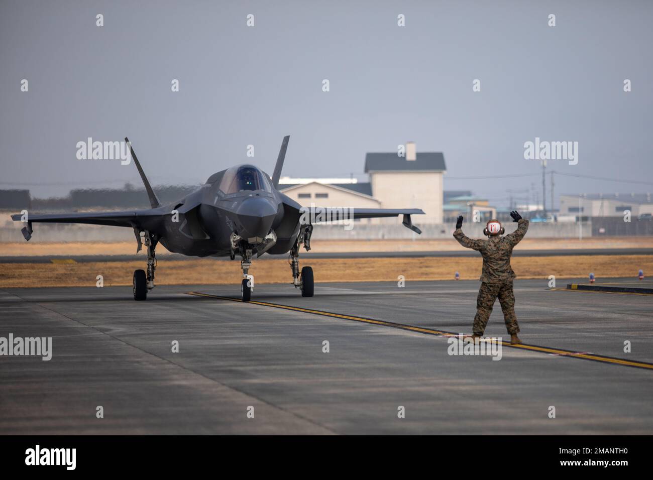 A U.S. Marine with Marine Fighter Attack Squadron (VMFA) 242 signals to ...