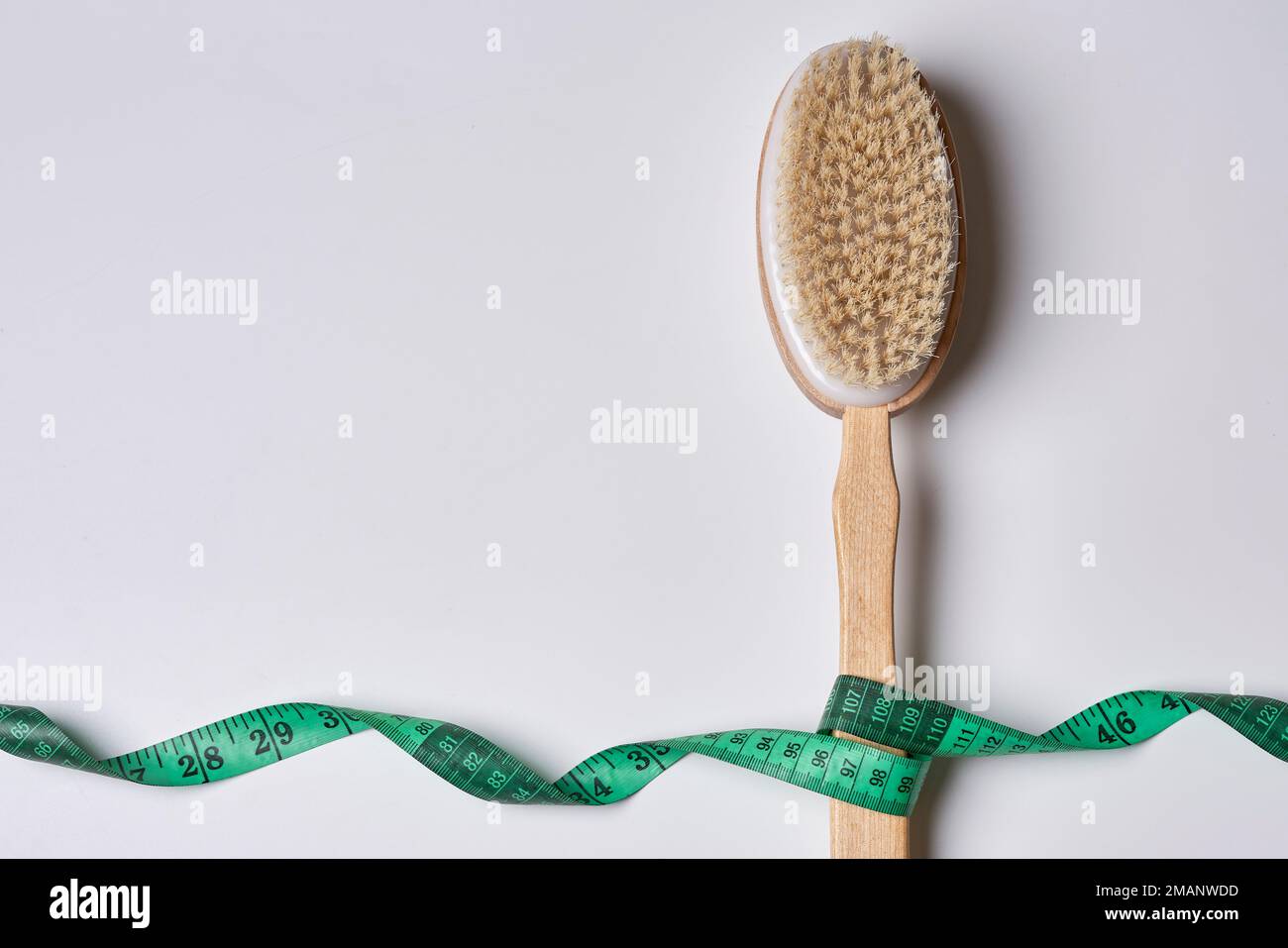 a wooden tooth brush with a measuring tape around it to show how the ...