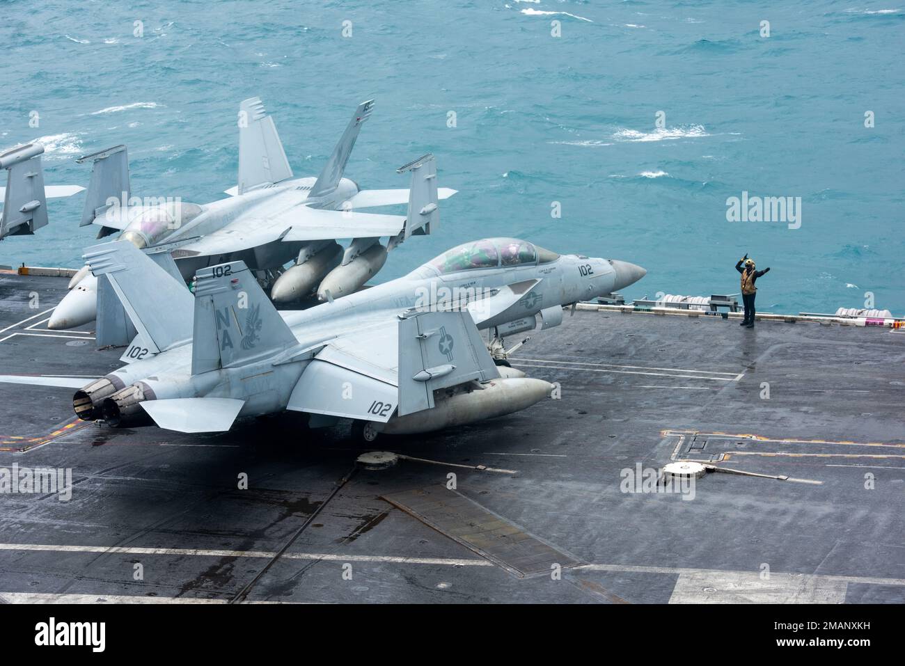 230119-N-NX635-1095 SOUTH CHINA SEA (Jan. 19, 2023) A U.S. Navy Sailor directs an F/A-18F Super ...