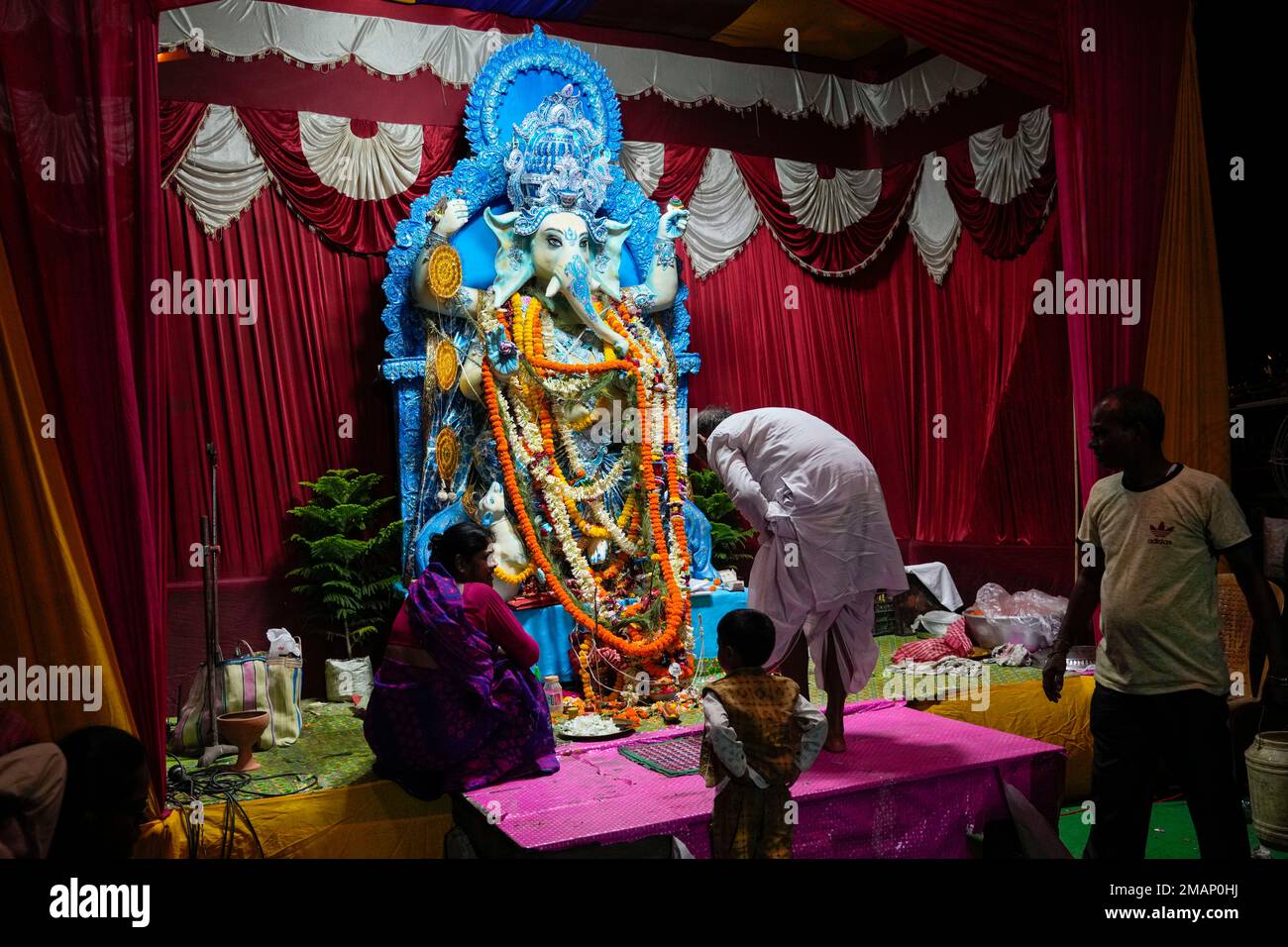 People arrange worship material for elephant-headed Hindu god Ganesha ...