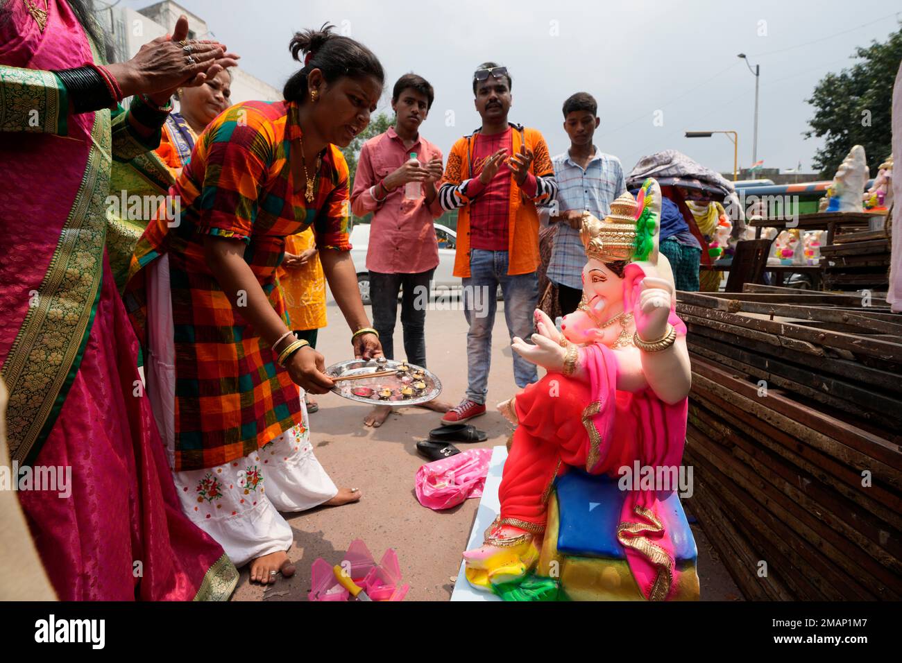 Devotees perform rituals in front of an idol of elephant-headed Hindu ...