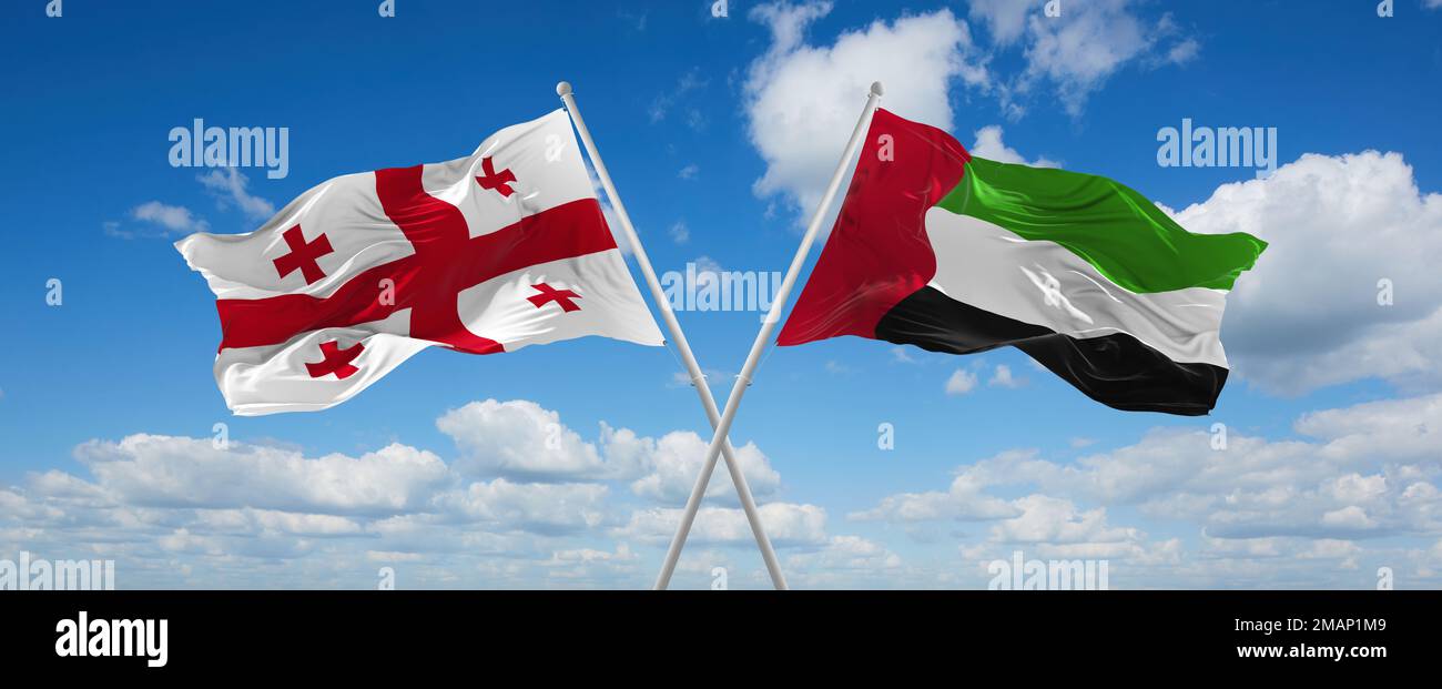 two crossed flags United Arab Emirates and Georgia waving in wind at ...