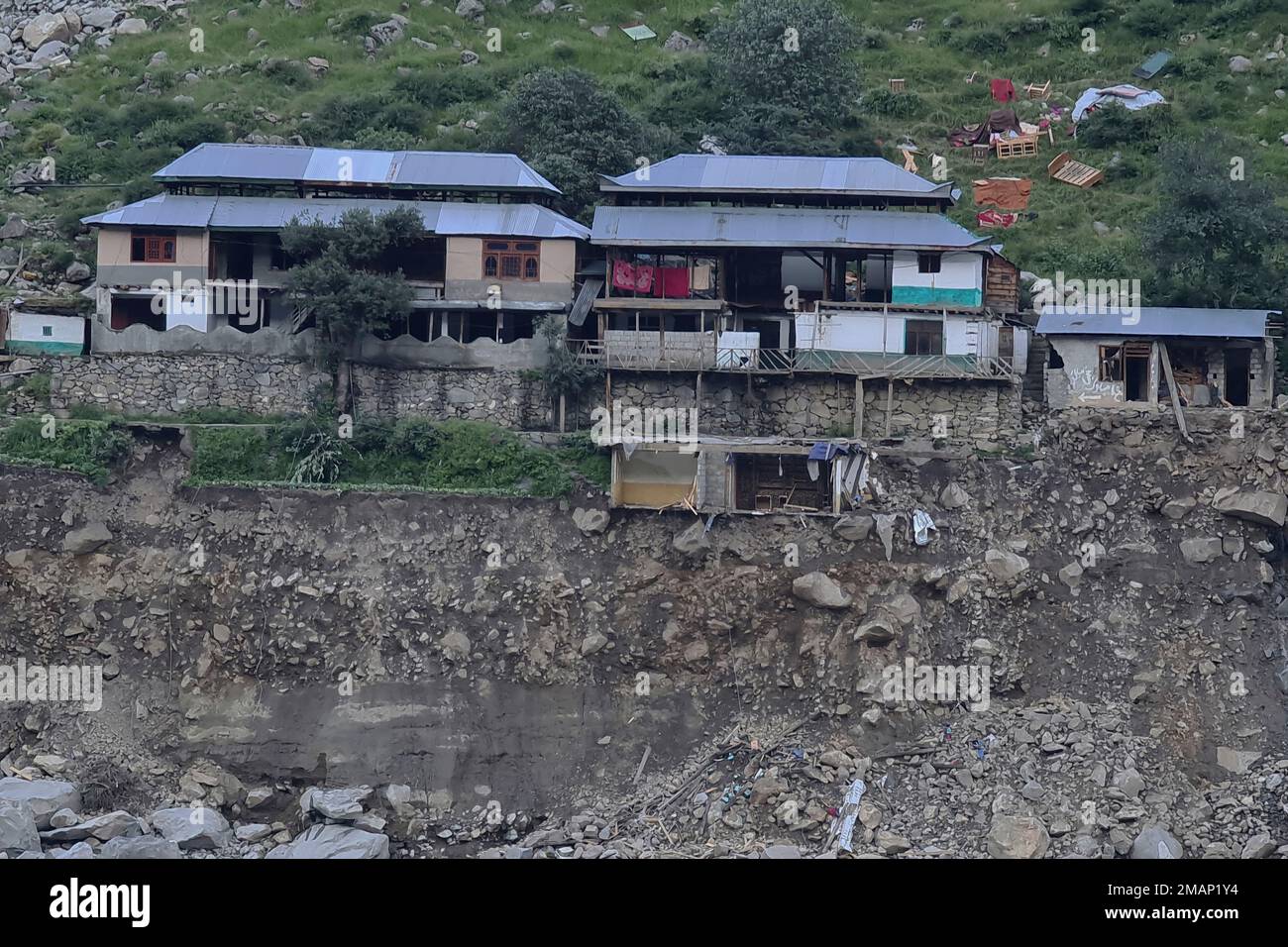 Homes destroyed by floodwaters hang to a cliff in the Kalam Valley in ...
