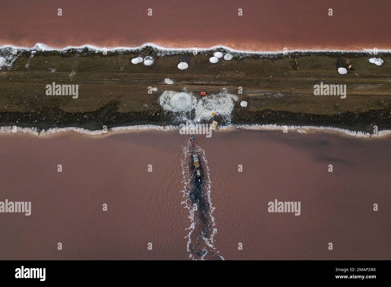 Salt collectors work at the salt flats of Pampatar on Margarita Island ...