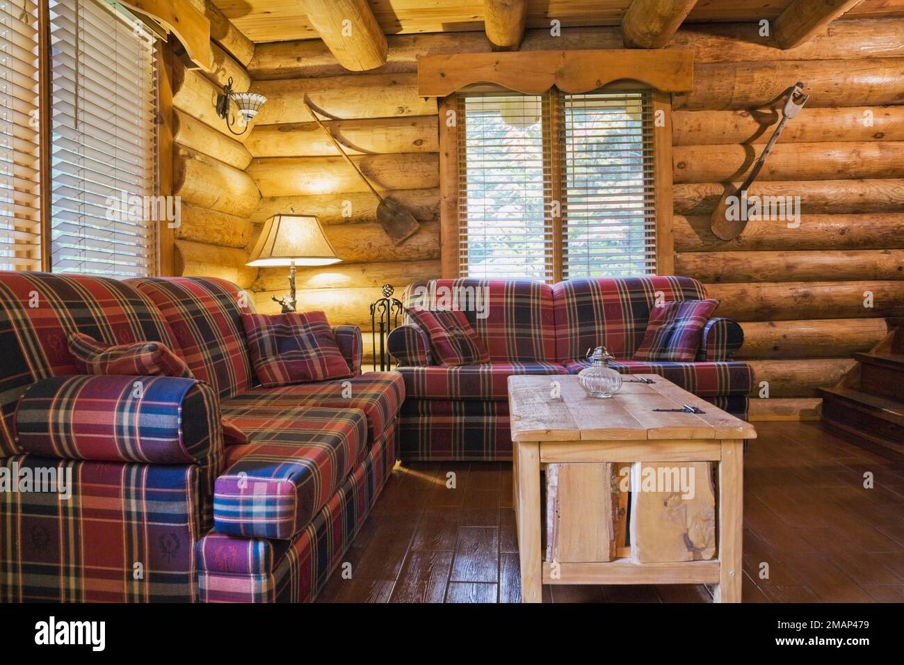 Red and blue tartan sofas with rustic wooden chest coffee table in ...