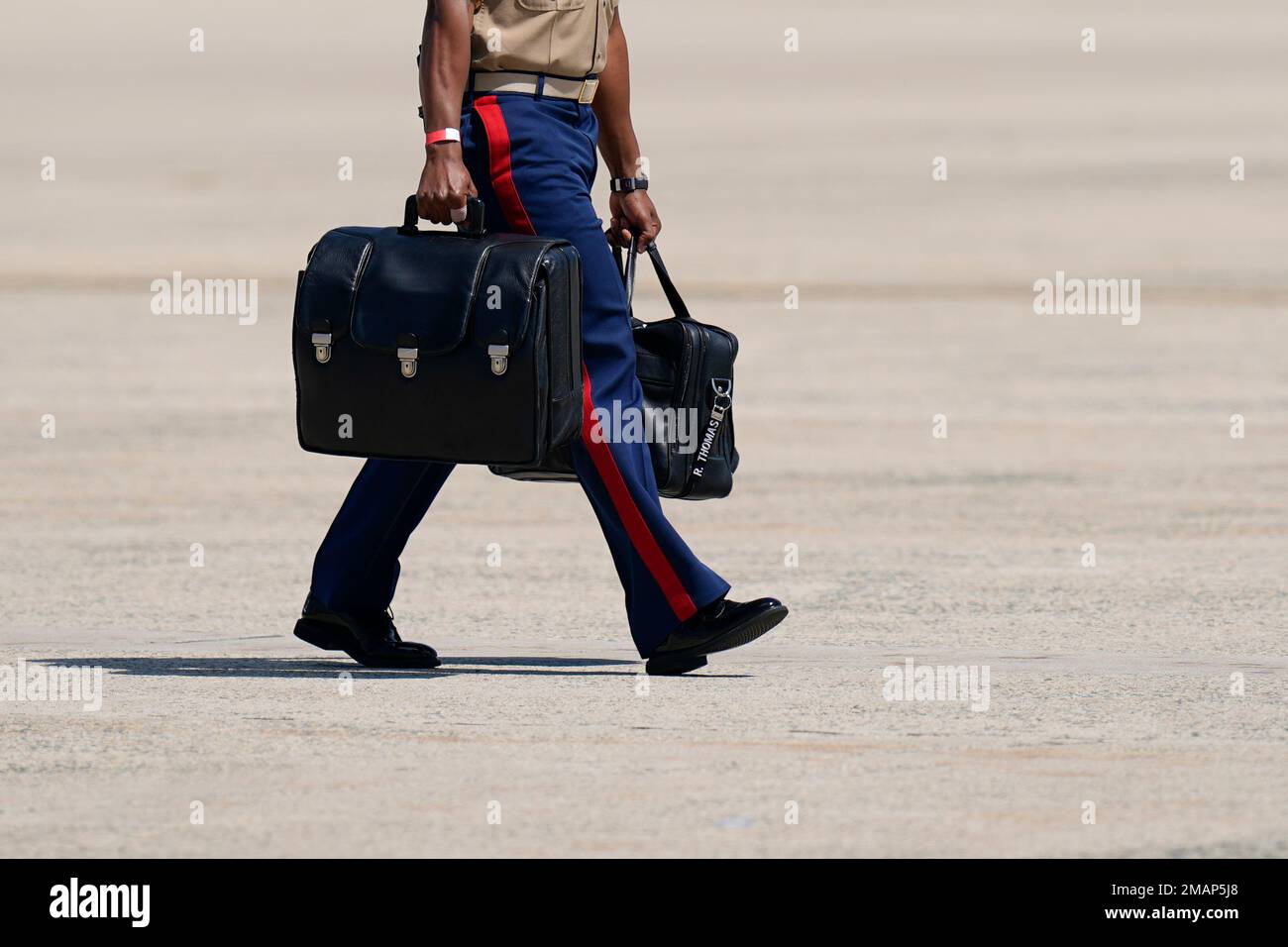 A military aide carries the "President's emergency satchel," also known ...