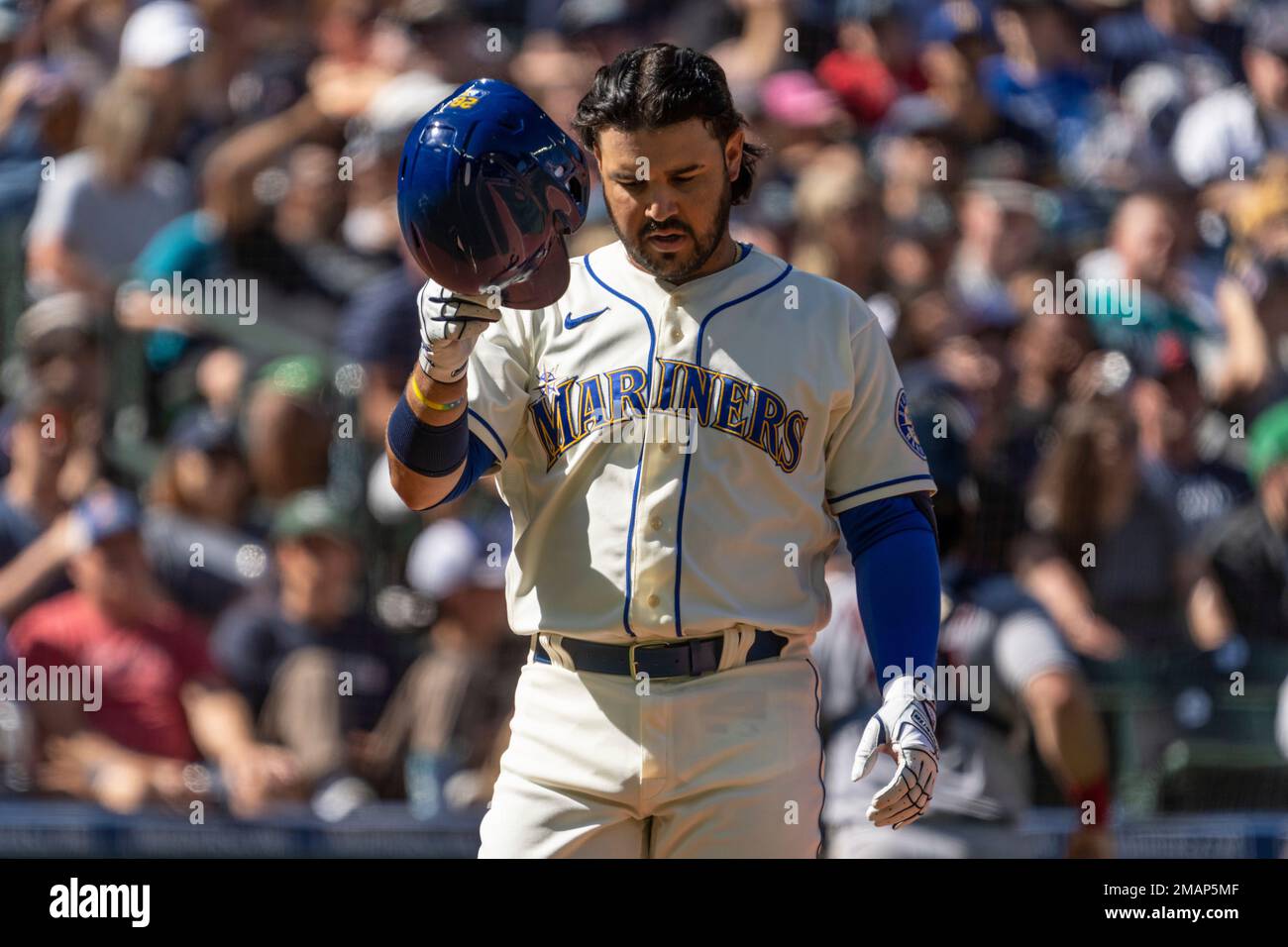 Seattle Mariners' Eugenio Suarez takes off a battle helmet after an at ...