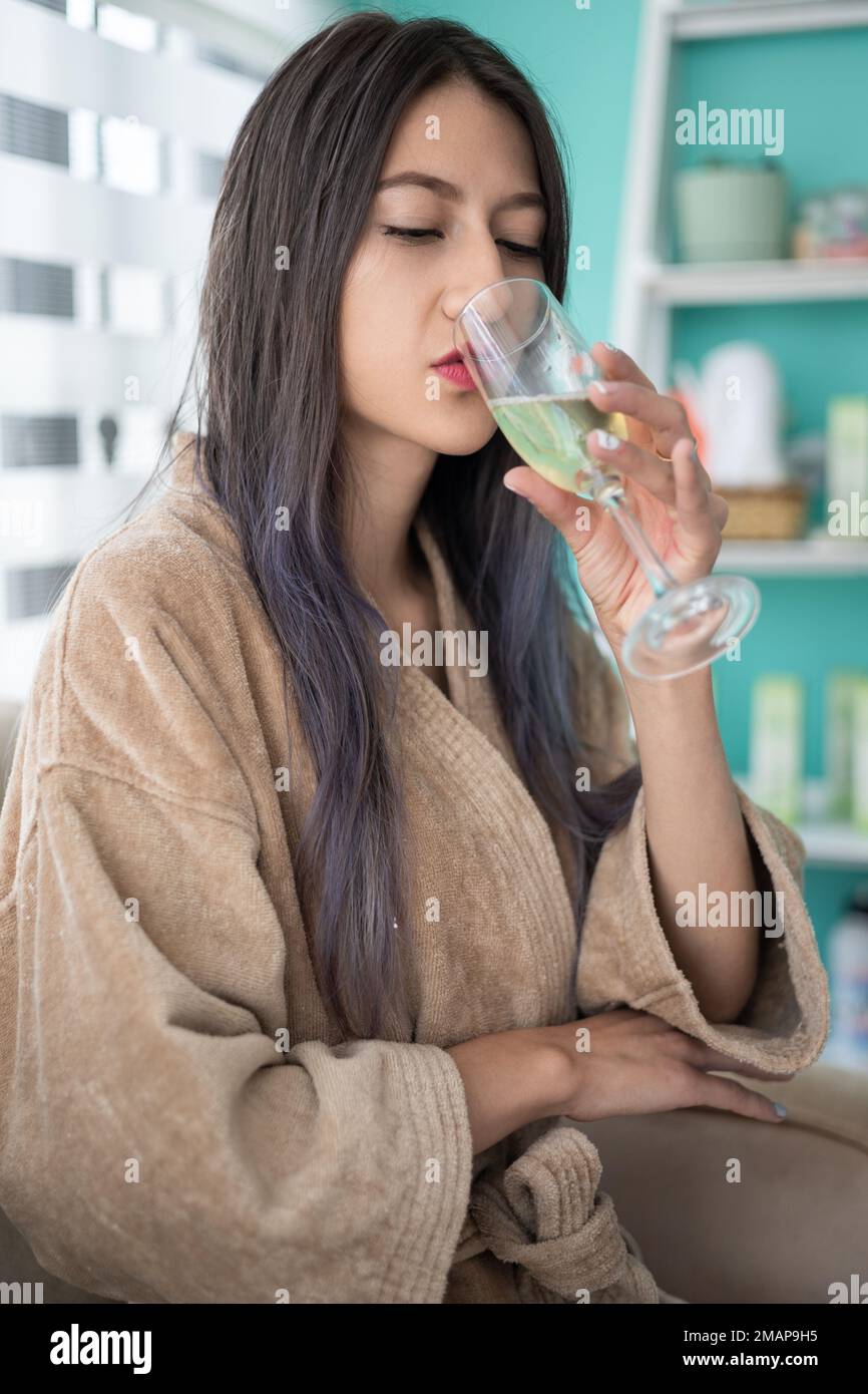 enjoying a glass of champagne while resting sitting young woman with ...