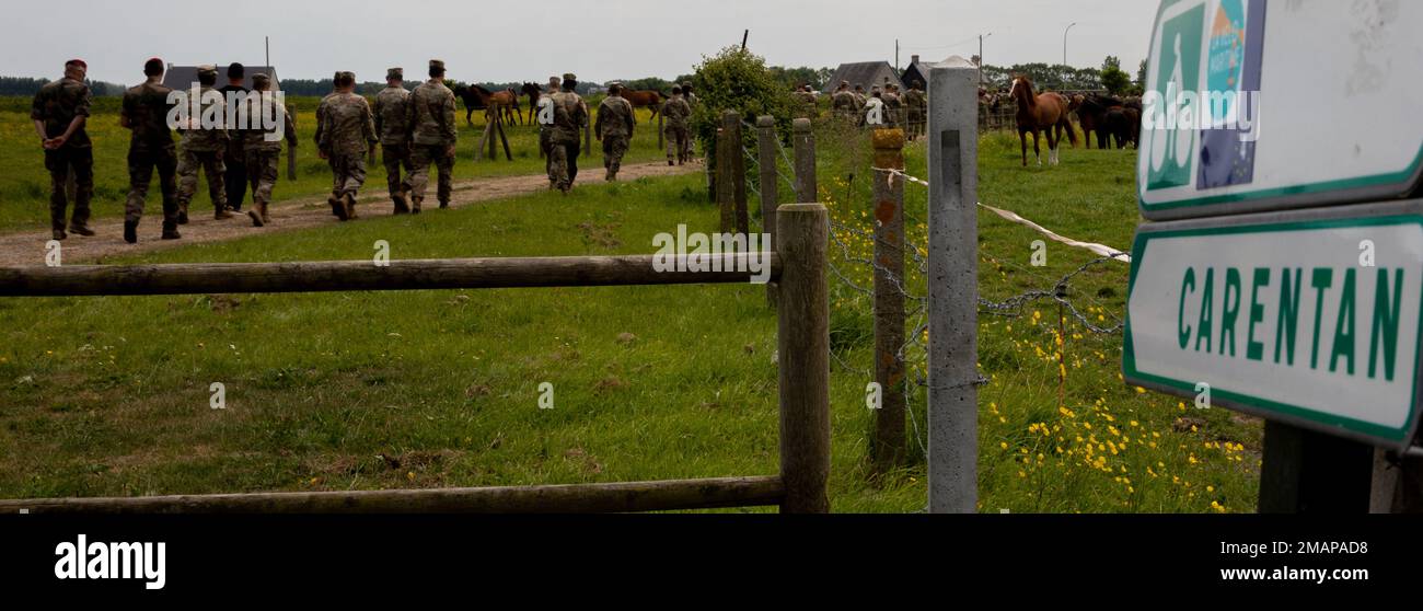 U.S. Soldiers walk through the fields during the Carentan Battlefield ...