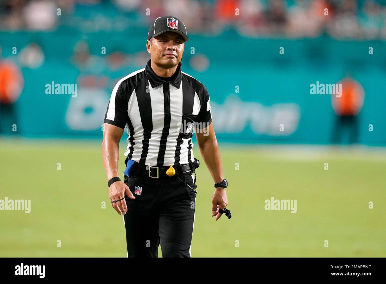 NFL referee Lo van Pham walks on the sideline during the first half of a NFL preseason football ...