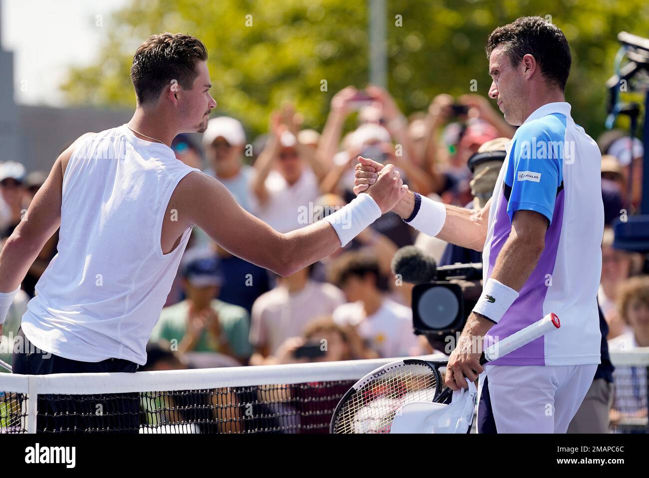 J.J. Wolf, of the United States, shakes hands with Roberto Bautista ...