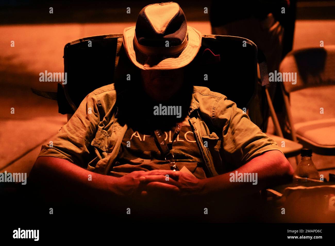 A spectator naps in a chair near the Saturn V visitor center hours ...