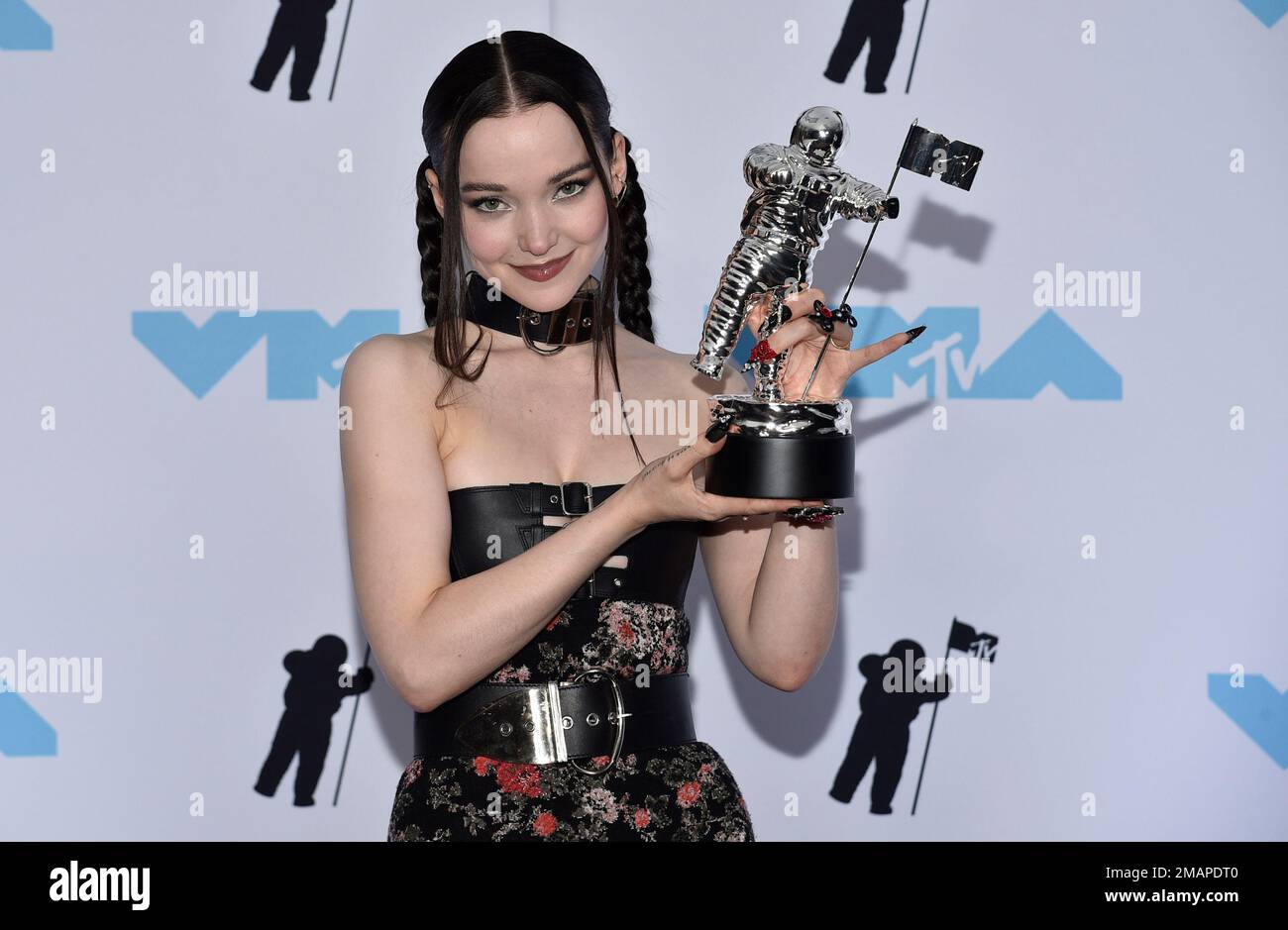 Dove Cameron poses in the press room with her award for best new artist ...
