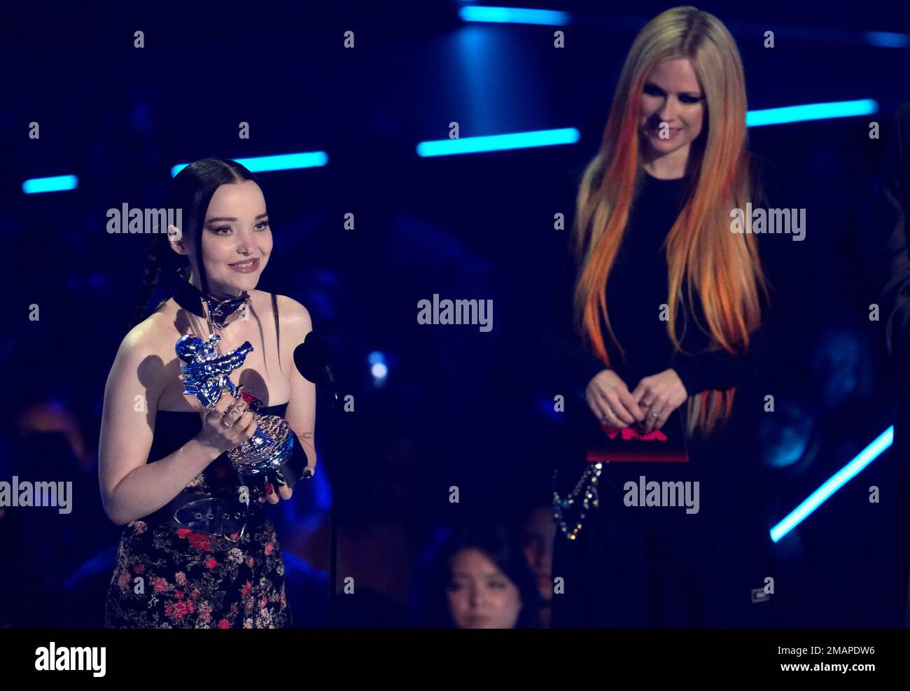 Dove Cameron, left, accepts the award for best new artist from ...