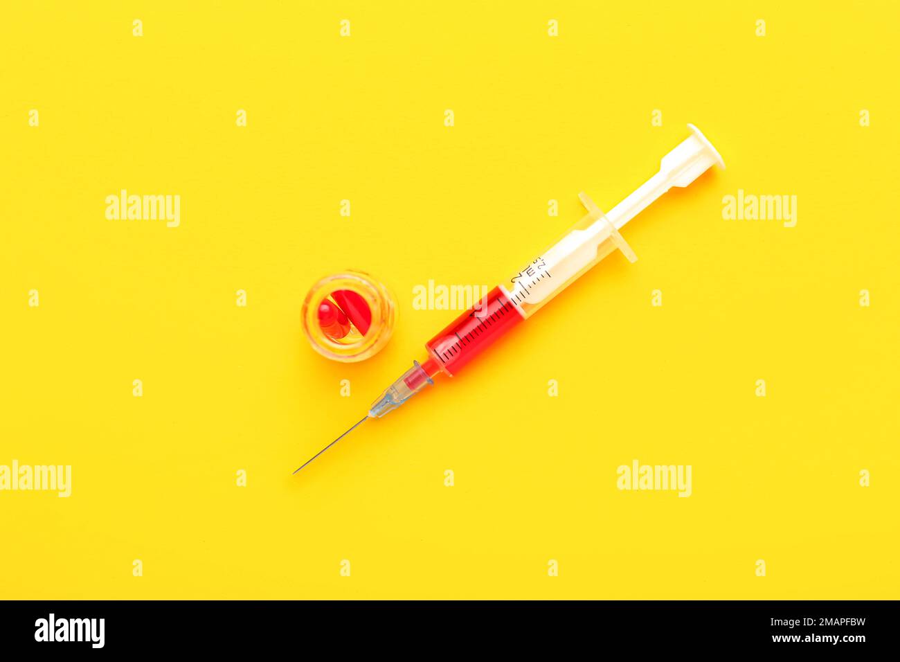Medical syringe with blood, ampule and pills on yellow background Stock ...