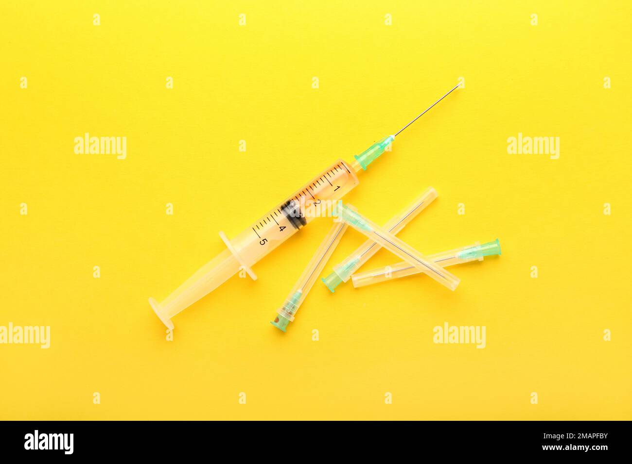 Medical syringe with needles on yellow background Stock Photo - Alamy