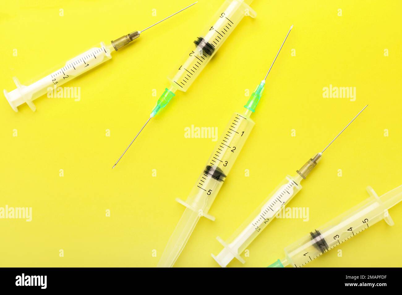 Empty medical syringes on yellow background Stock Photo - Alamy
