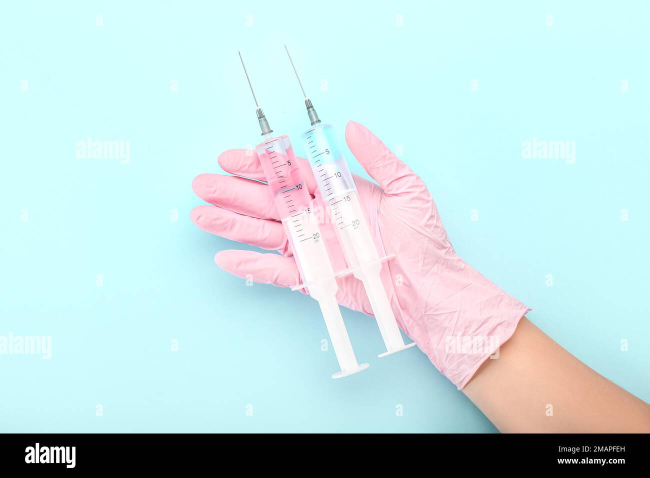 Female doctor with syringes on blue background Stock Photo - Alamy