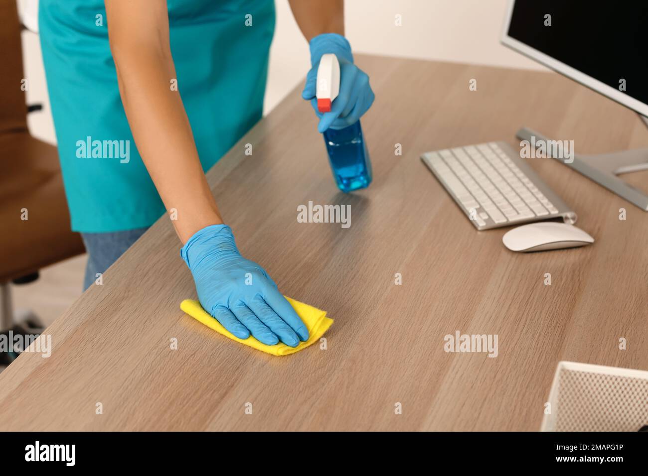 Female janitor cleaning desk in office, closeup Stock Photo - Alamy