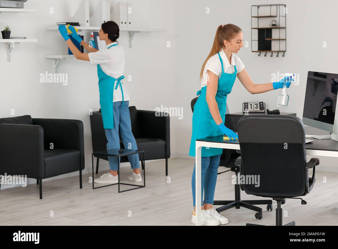 Female janitor cleaning computer screen in office Stock Photo - Alamy