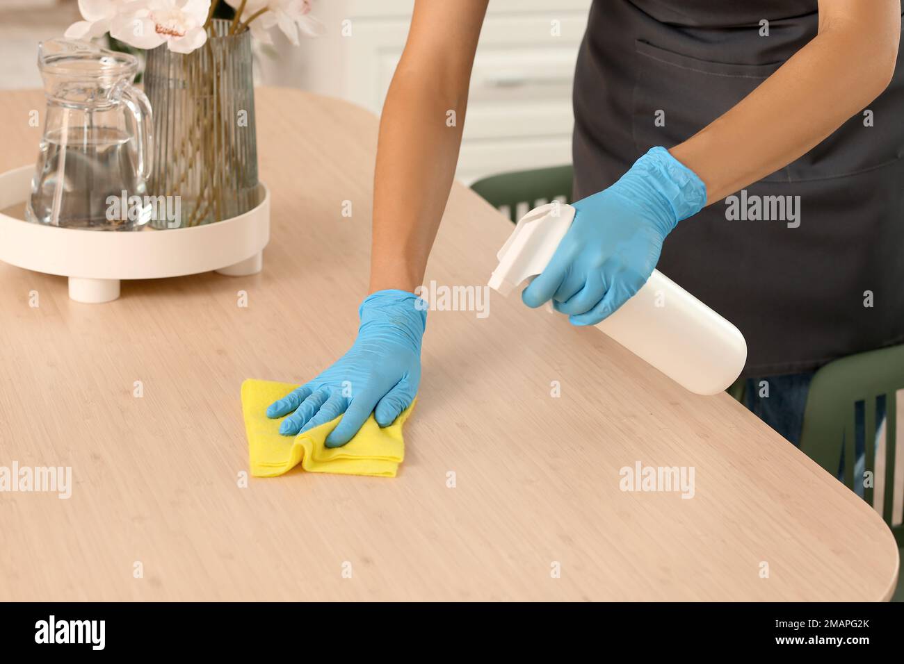Female janitor cleaning dining table in kitchen, closeup Stock Photo ...