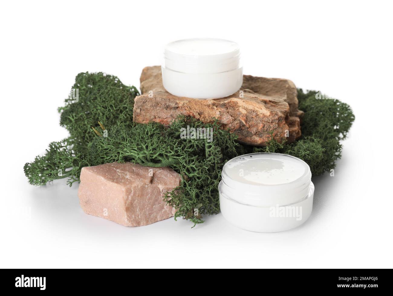 Jars of cream with green moss and rocks on white background Stock Photo ...