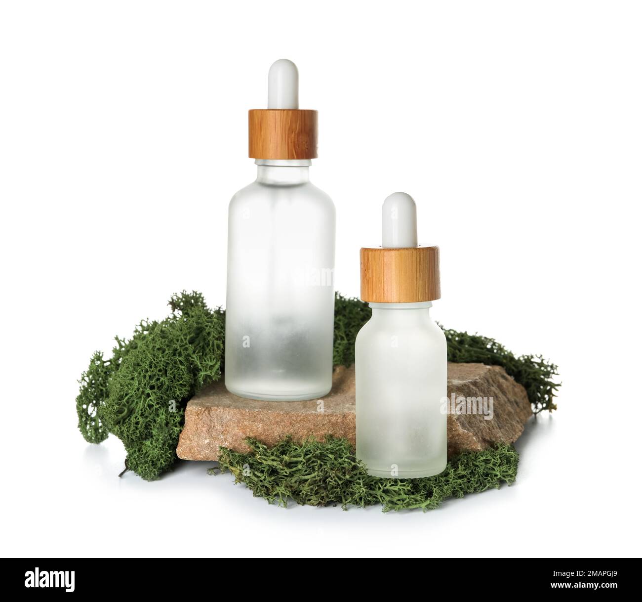Cosmetic dropper bottles with green moss and rock on white background ...