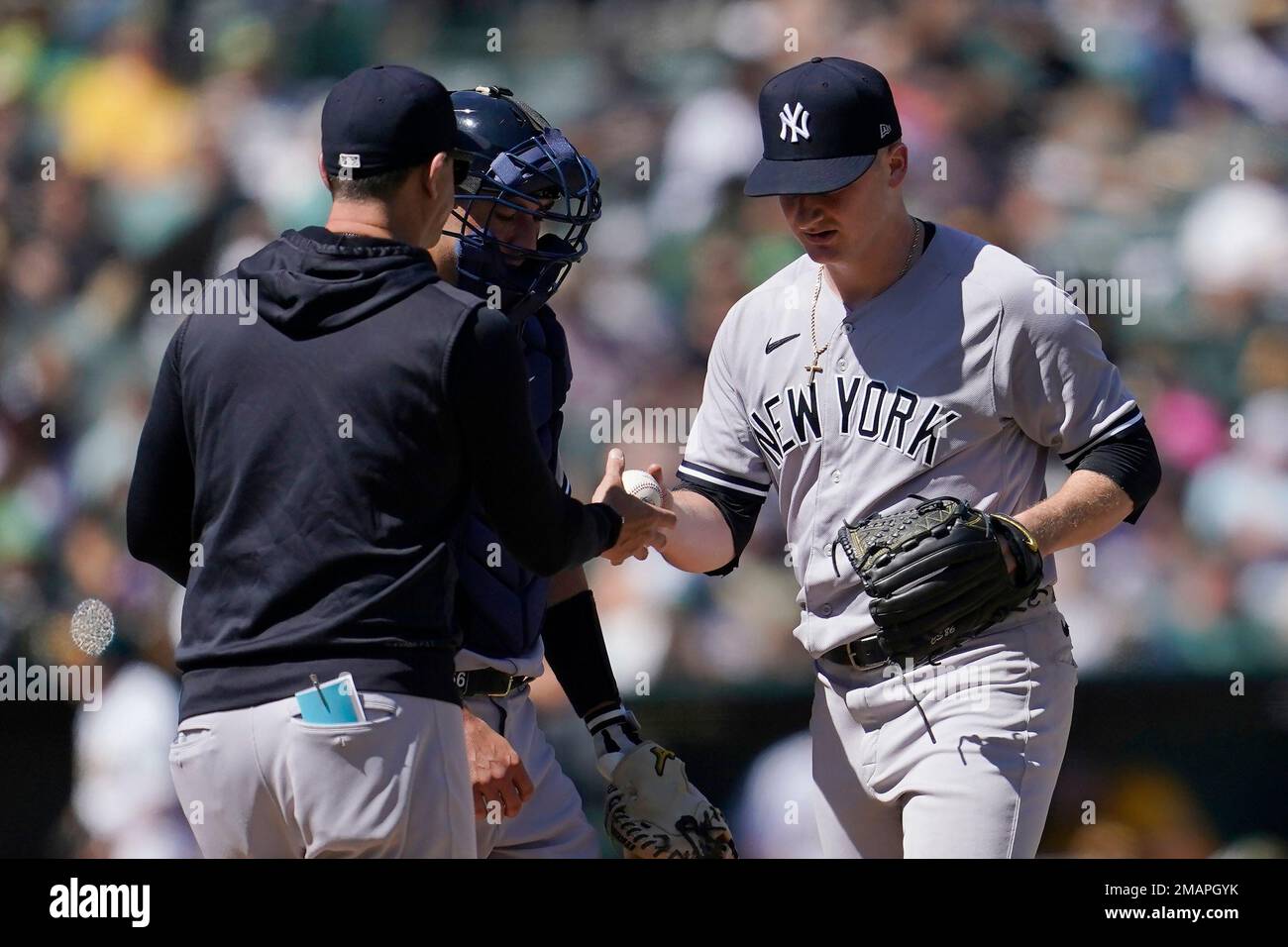 New York Yankees pitcher Clarke Schmidt, right, hands the ball to ...