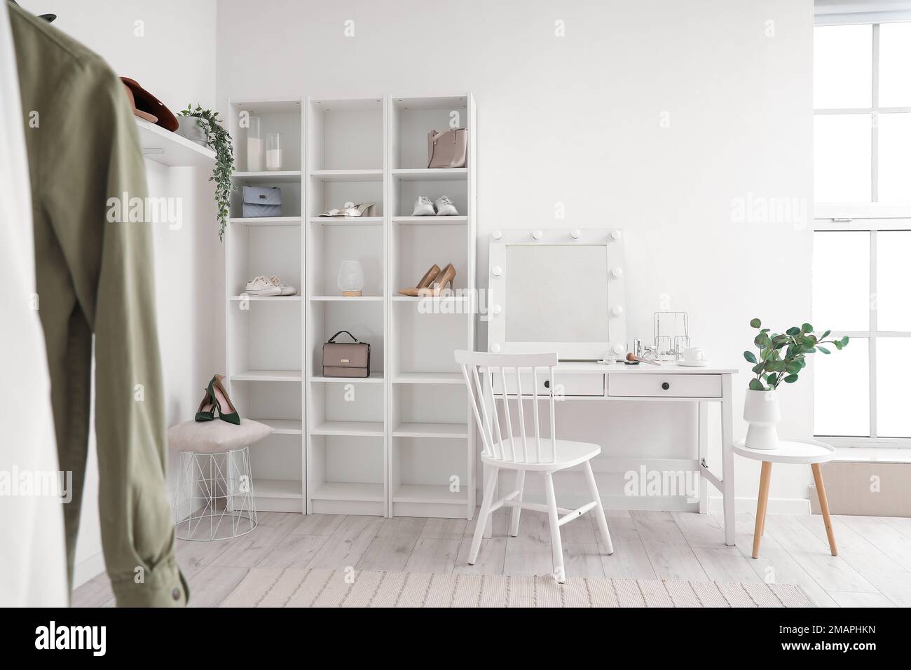 Interior of light makeup room with table and shelving unit Stock Photo ...
