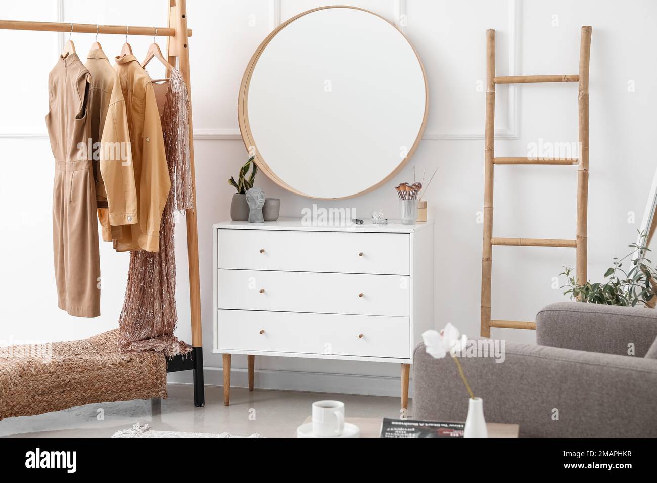Interior of stylish dressing room with mirror, clothes and drawers ...