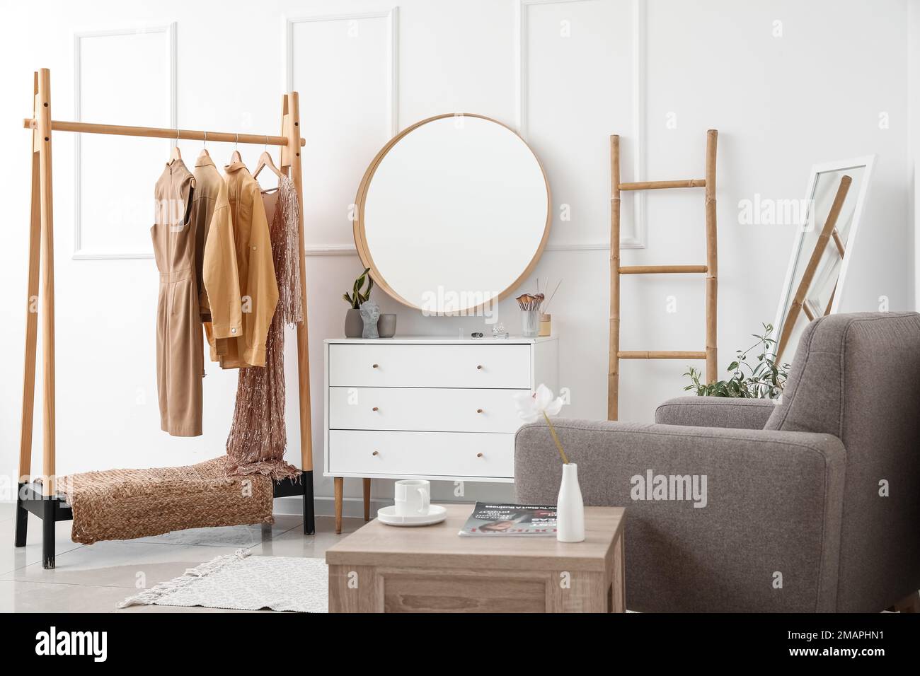Interior of stylish dressing room with mirror, clothes and drawers ...