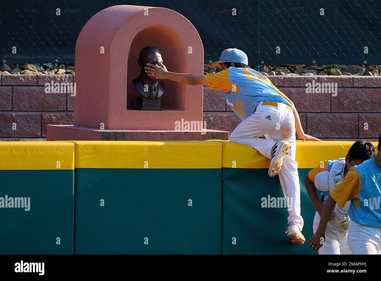 Honolulu's Kama Angell climbs the centerfield fence at Lamade Stadium ...