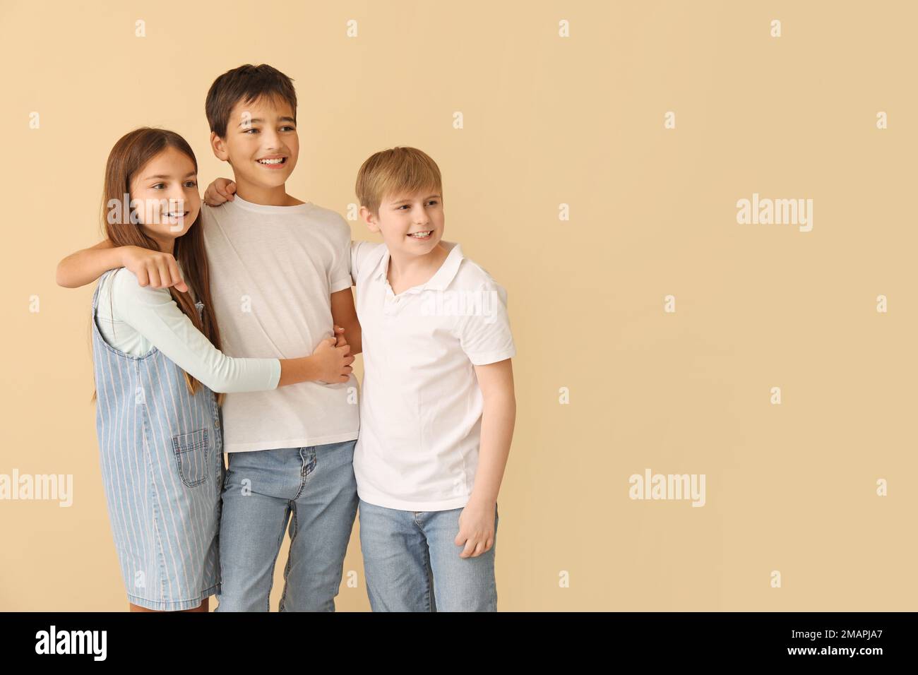Little friends hugging near beige wall Stock Photo - Alamy