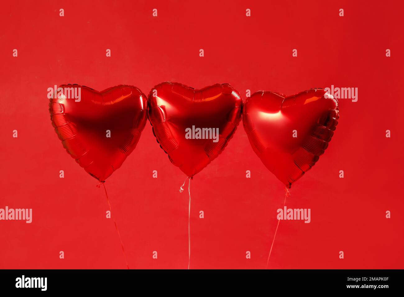 Heart shaped balloons for Valentine's Day on red background Stock Photo ...