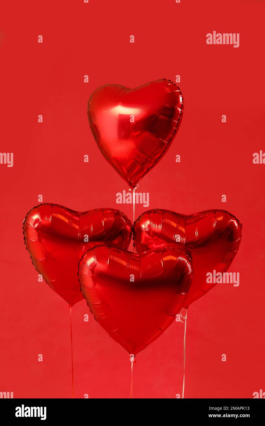 Heart shaped balloons for Valentine's Day on red background Stock Photo ...