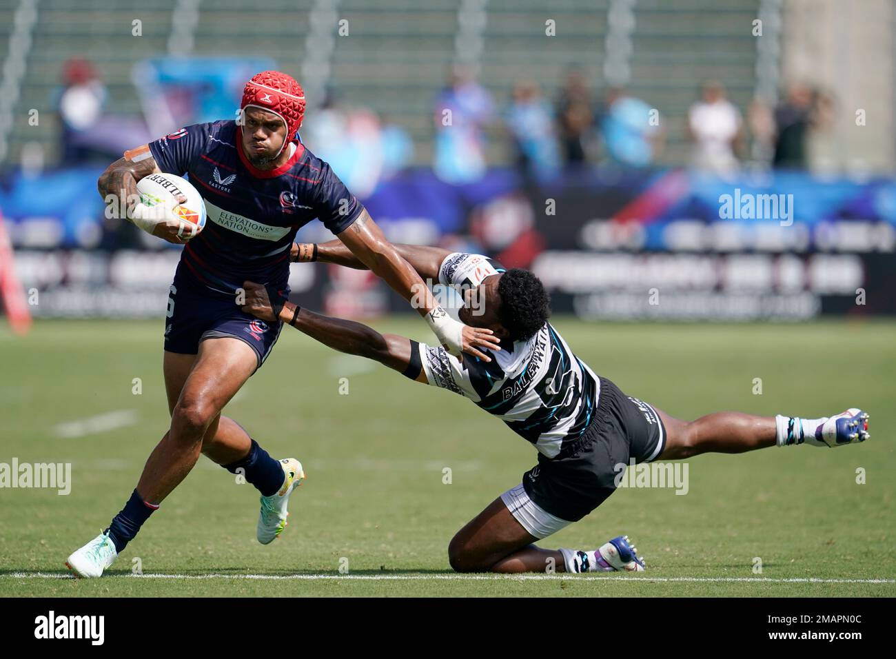 United States' Maka Unufe, left gets past the tackle of Fiji's Iosefo ...