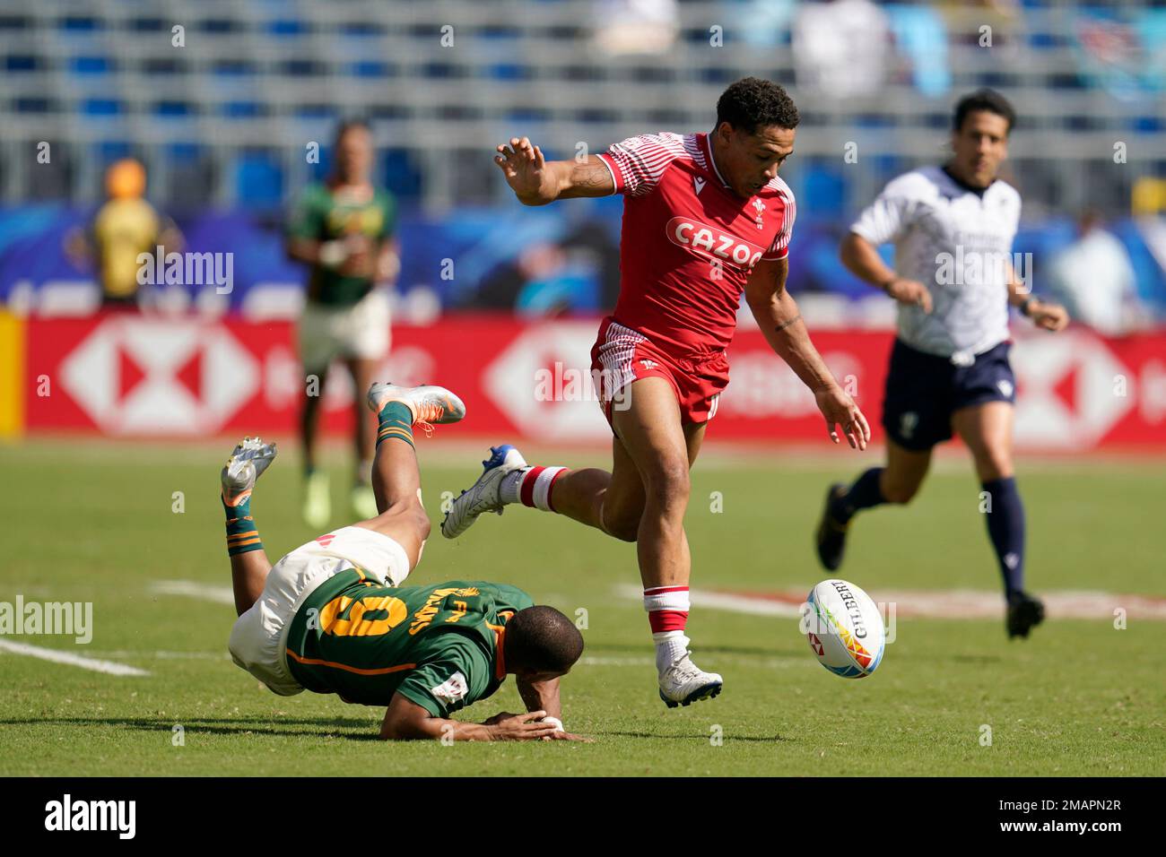 Wales' Lloyd Lewis, right kicks th ball past South Africa's Shaun ...