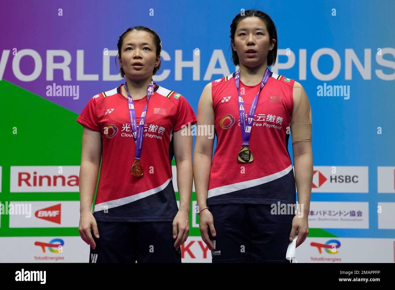 Chen Qing Chen, left, and Jia Yi Fan of China listen to Chinese national anthem s they stand on ...