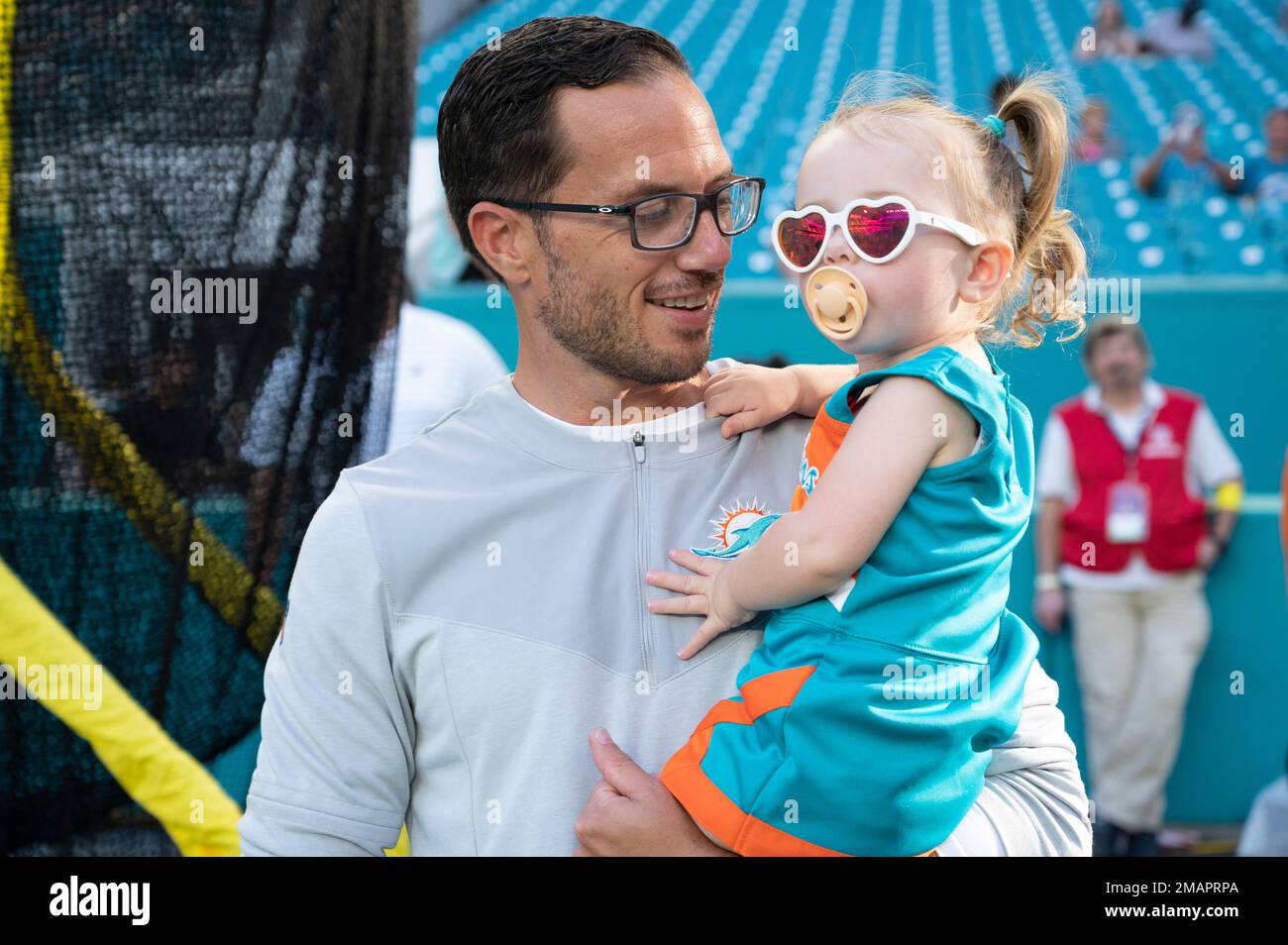 Miami Dolphins head coach Mike McDaniel holds his daughter Alya June on ...