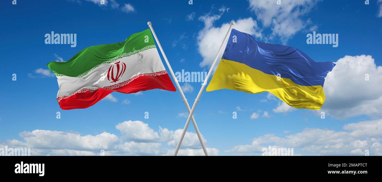 two crossed flags Ukraine and Iran waving in wind at cloudy sky ...