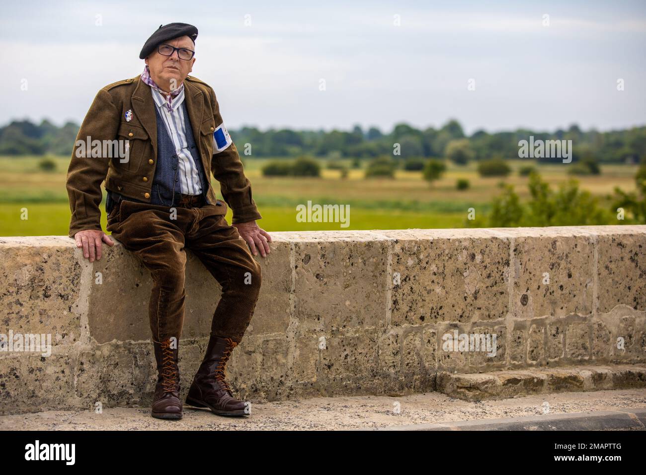 Man sits on La Fiere bridge in Normandy, France in a 1940's style ...