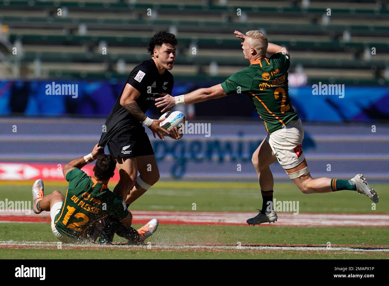 New Zealand's Caleb Tangitau, centre is tackled by South Africa's ...