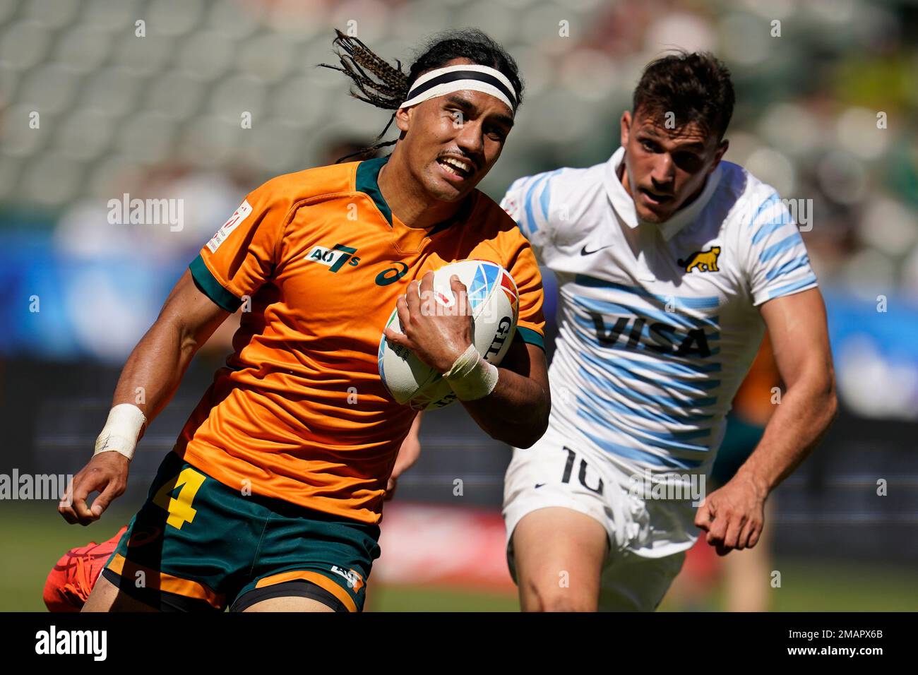 Australia's Dietrich Roache, left, runs onto score a try past Argentina ...