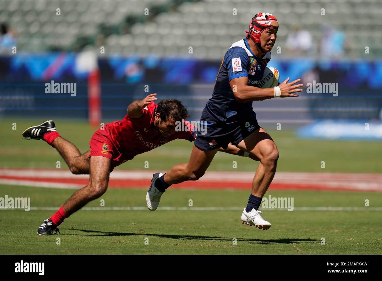 Japan's Taichi Yoshizawa, right runs past the tackle of Spains Ramon ...