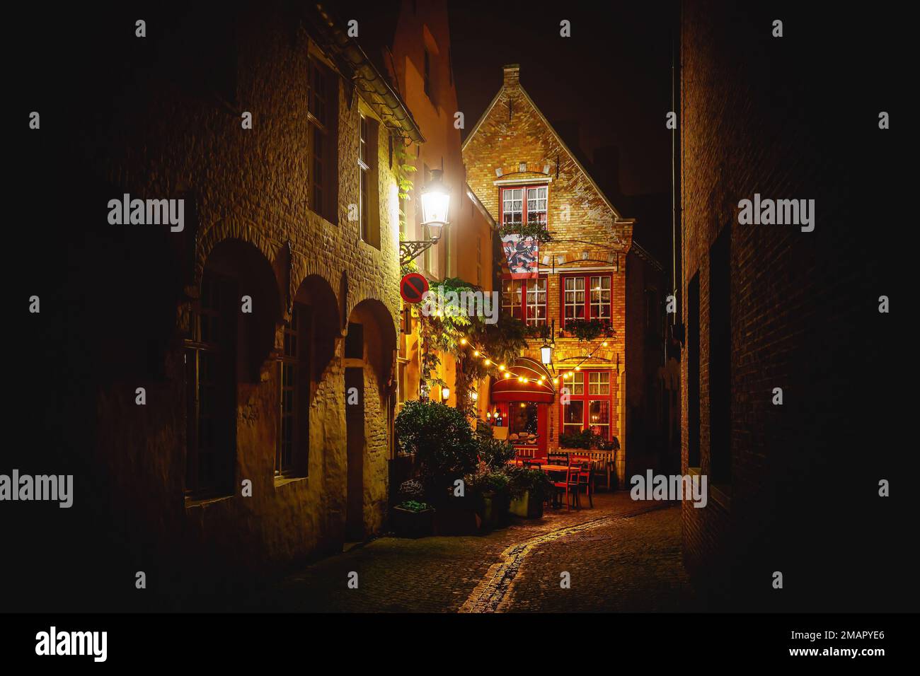 Cozy restaurant on streets of the old town at night. Paving stones of ...