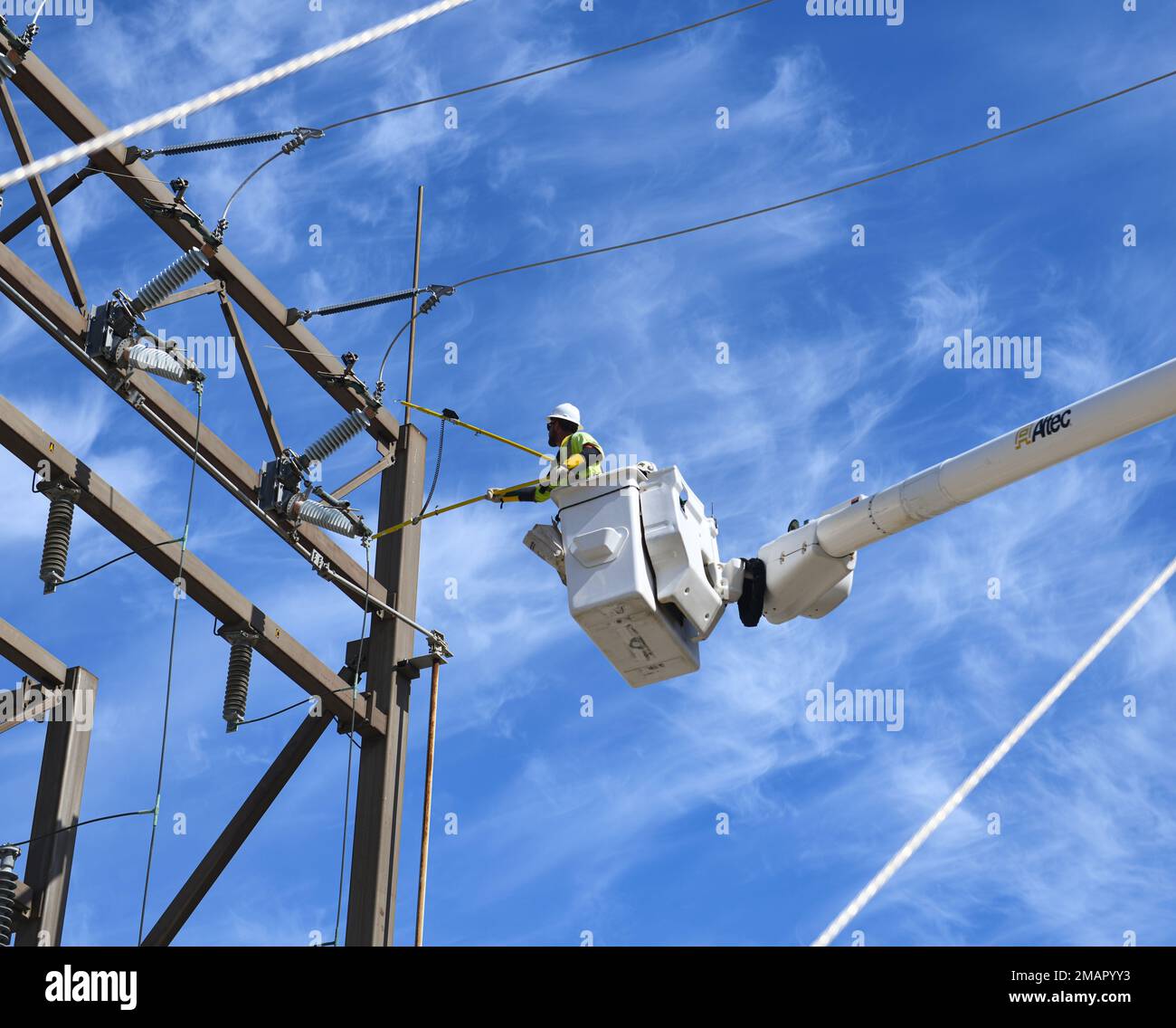 Contractors test voltage using “hot sticks” atop a lift at substation N ...